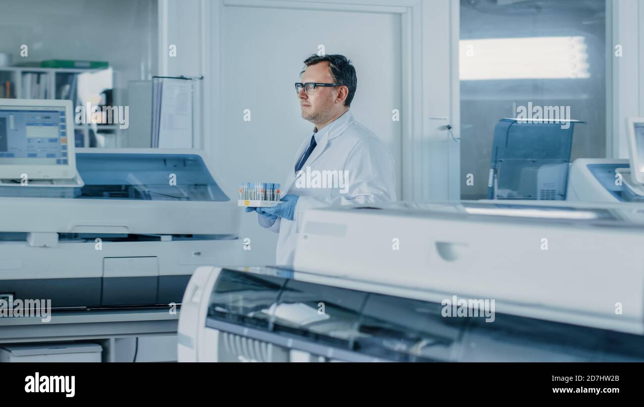 Male Research Scientist Walks Through Laboratory with Tray of Test ...