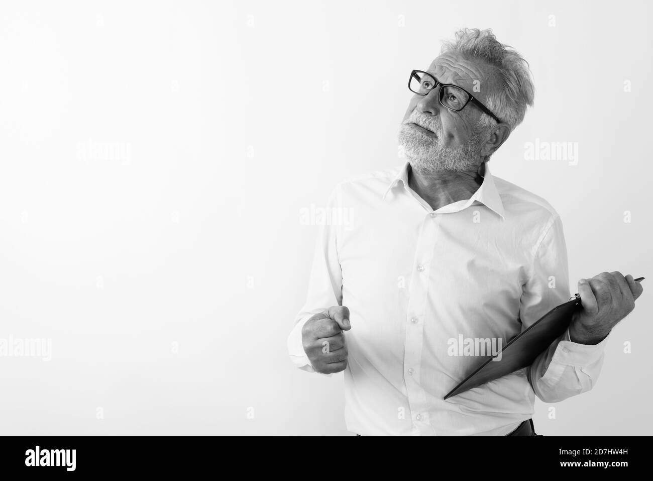 Studio shot of angry senior bearded man thinking while holding ...