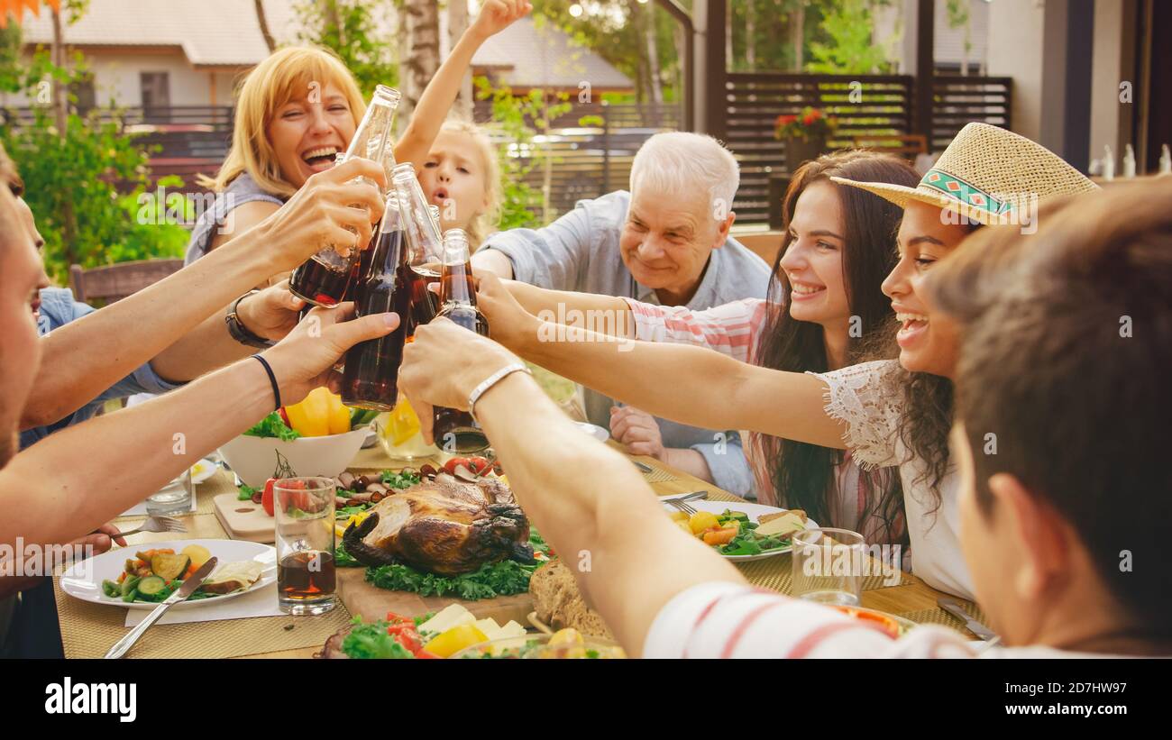 Family and Friends Gathered Together at the Table Raise Glasses and ...