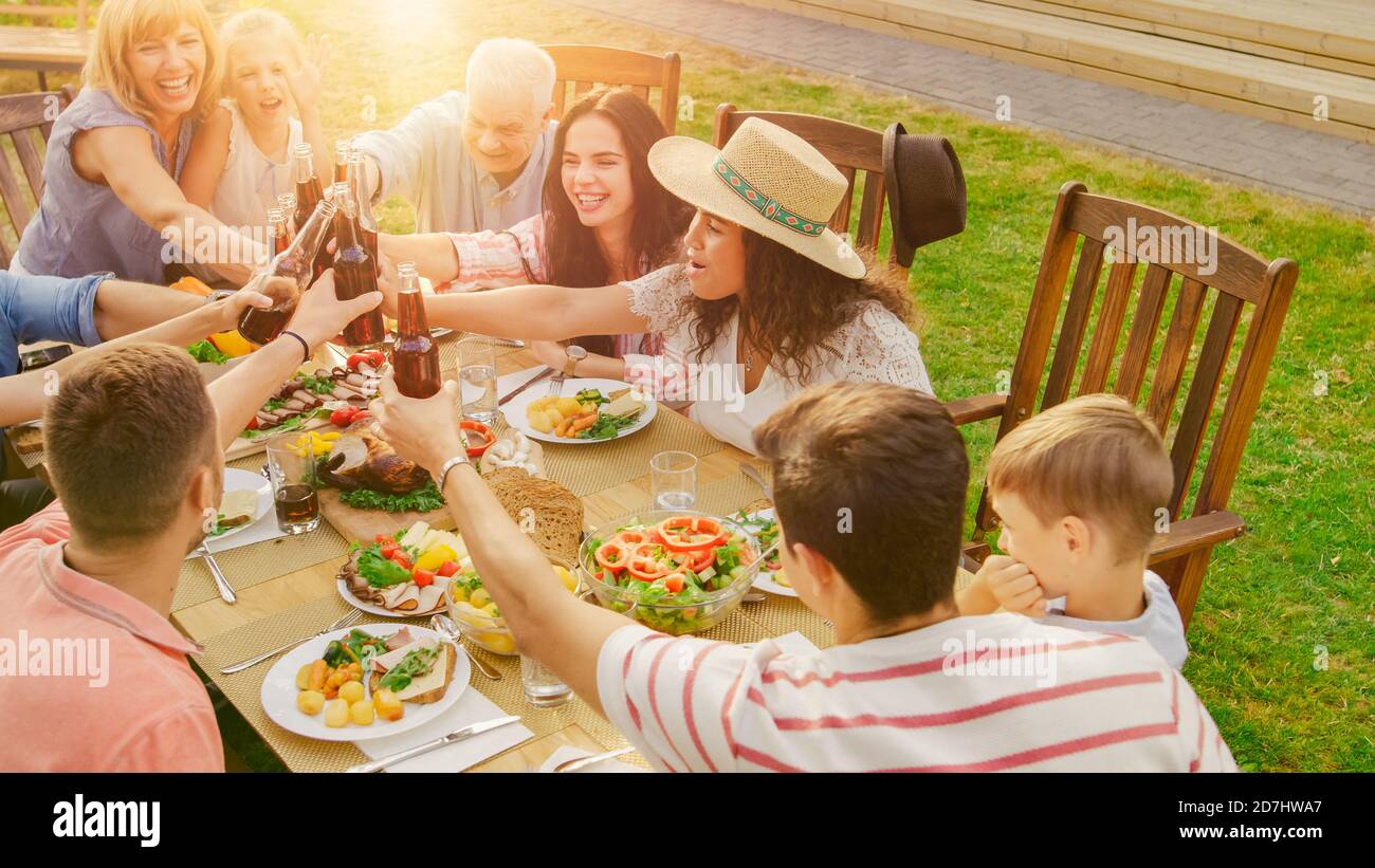 Family and Friends Gathered Together at the Table Raise Glasses and ...