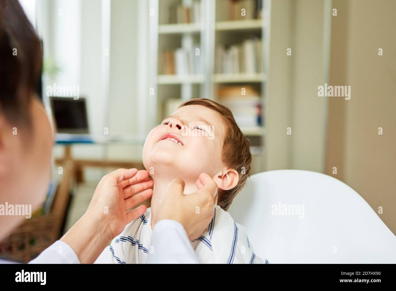 Pediatrician palpates the tonsils and lymph nodes in a child with ...
