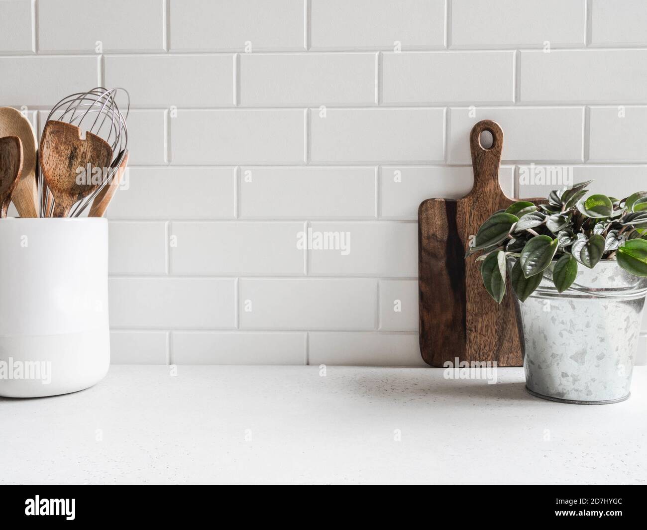 Stylish white kitchen background with kitchen utensils and green ...