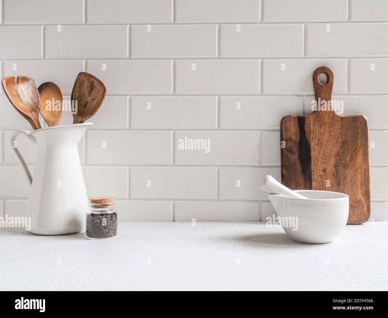 Stylish white kitchen background with kitchen utensils standing on ...