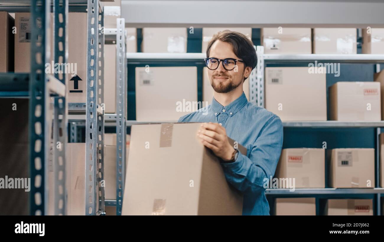 Warehouse Worker Holds Cardboard Box. In the Background, Rows of ...