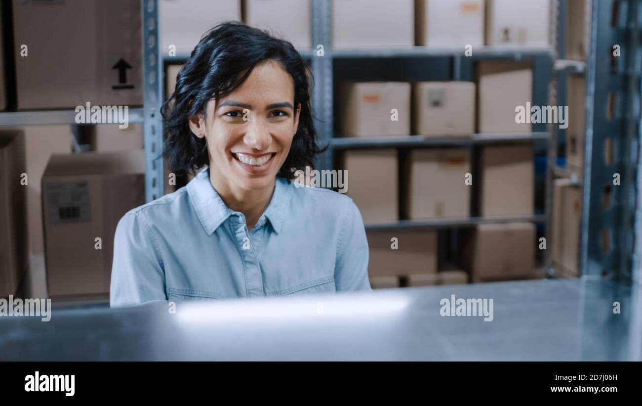 Female Warehouse Worker Smiles Charmingly at the Camera. In the ...