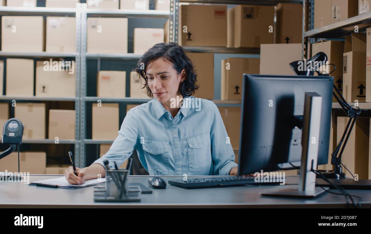Female Inventory Manager Works on a Computer while Sitting at Her Desk ...