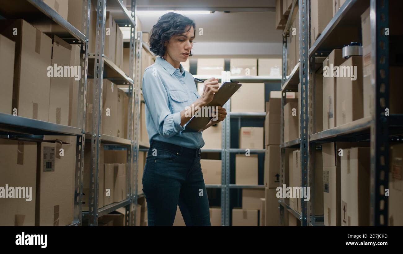 Female Inventory Manager Checks Stock, Writing in the Clipboard ...