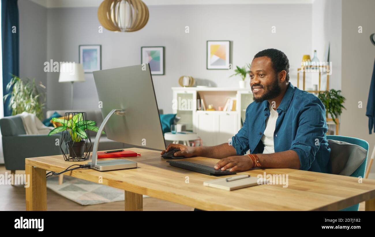 Handsome Black Man Works on a Personal Computer while Sitting at the ...
