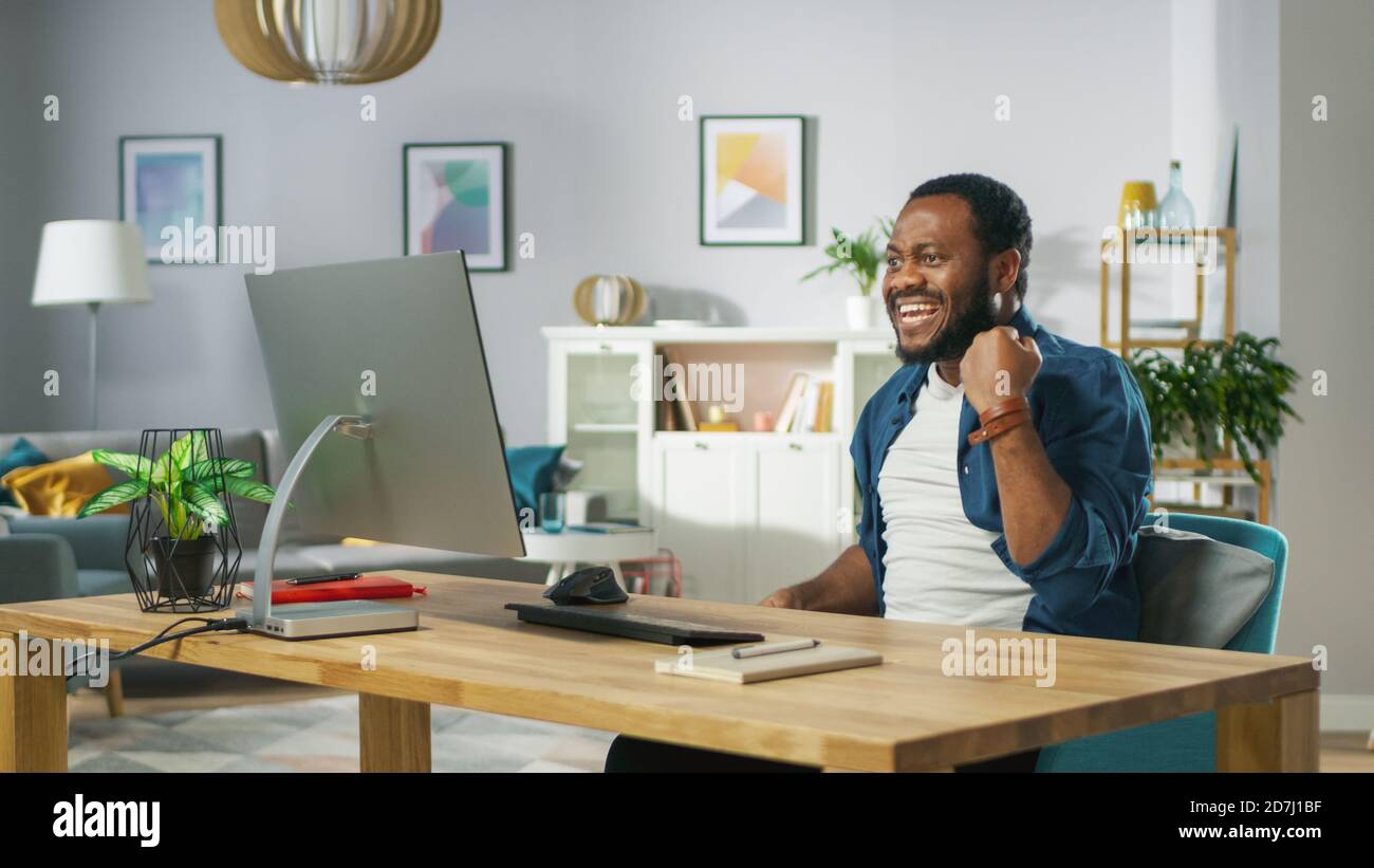 Excited Young Man Uses Personal Computer at Home, Wins Big, Does "Yes ...