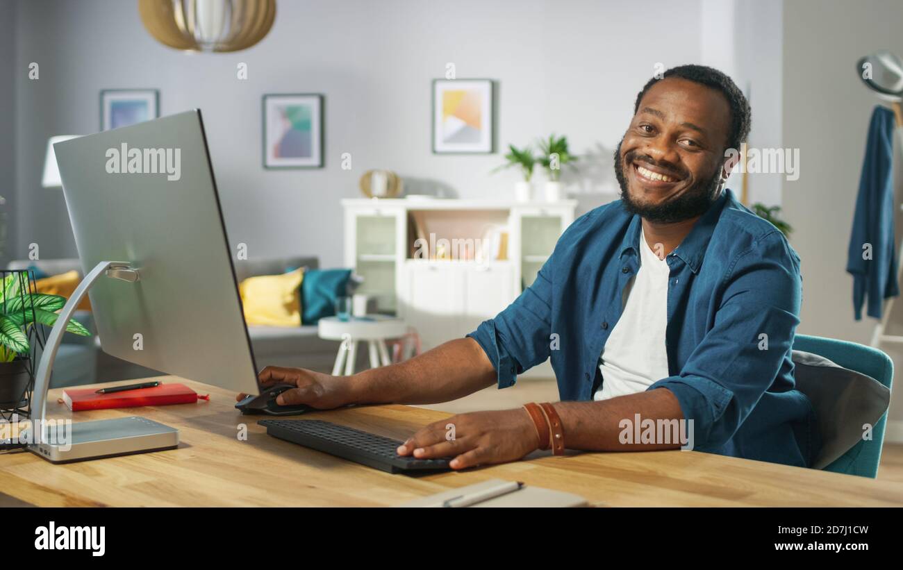 Smiling Young Man Uses Personal Computer, Nods in Agreement and Smiles ...