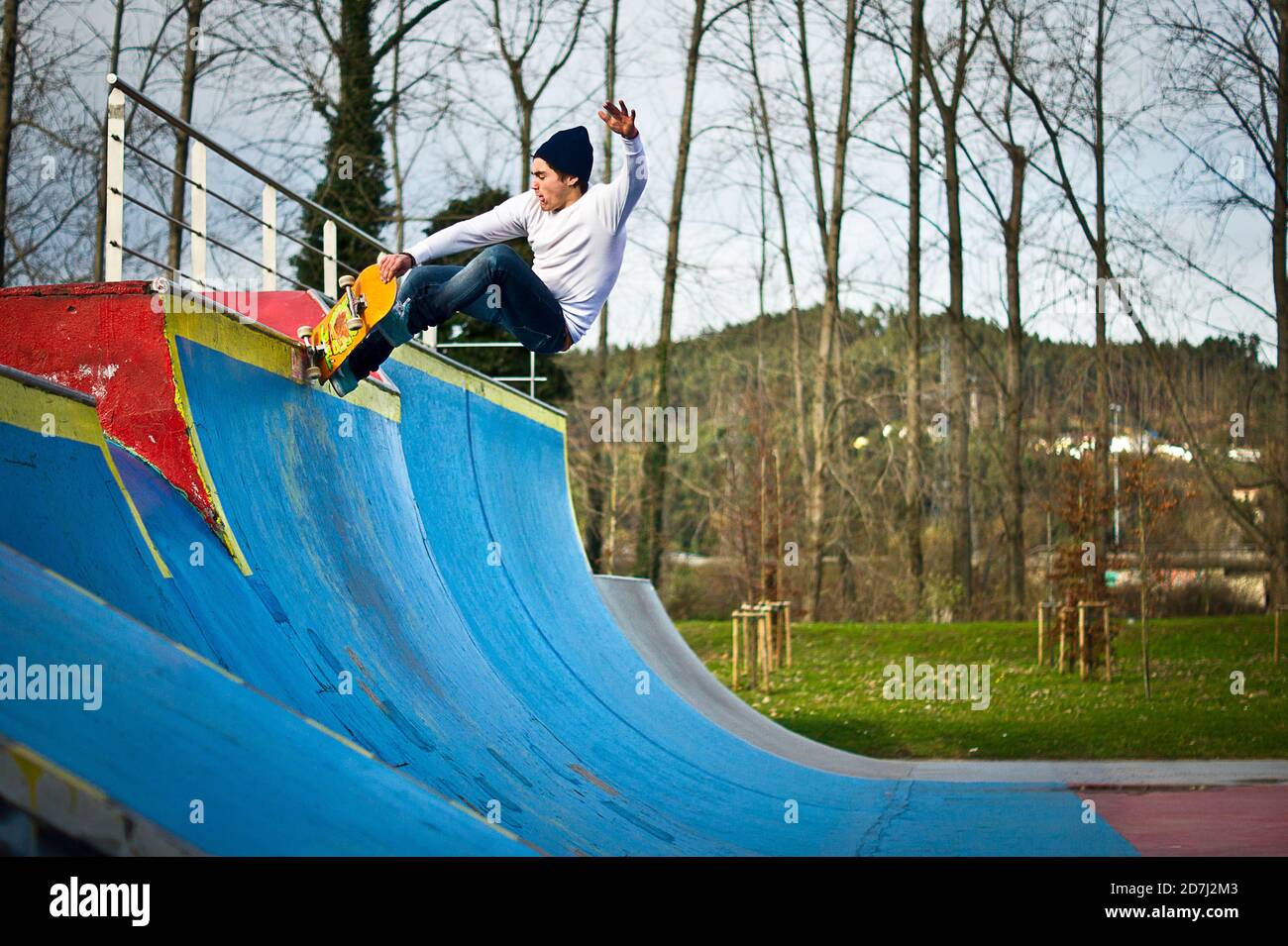 Young skater turning high on the skatepark with a colorful view of the ...