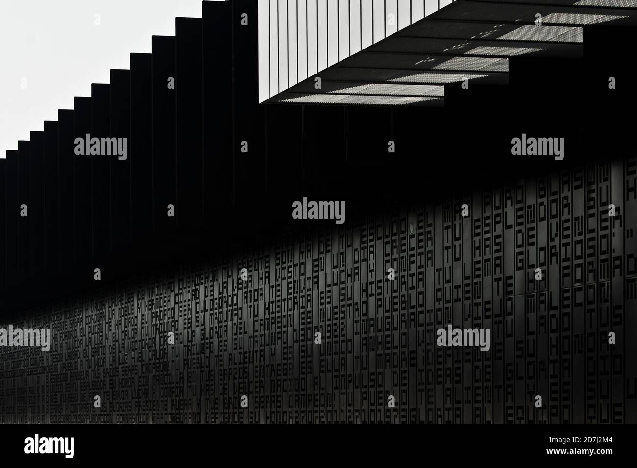 Black wall of a football stadium with letters and words on it and a new ...