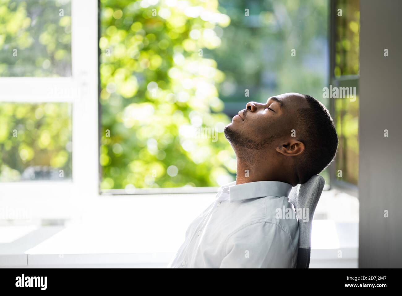 Fresh Air At Desk In Office African American Relaxing Near Window Stock ...
