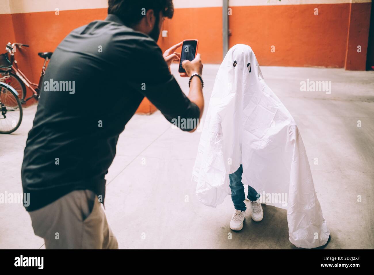 Father photographing child dressed as ghost Stock Photo - Alamy
