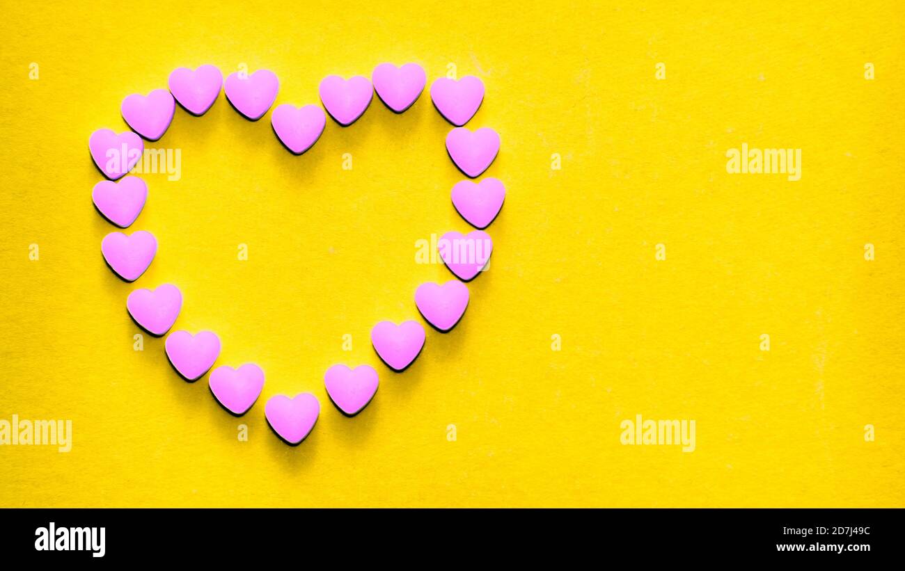Heart-shaped tablets that form a heart shape on a yellow background ...