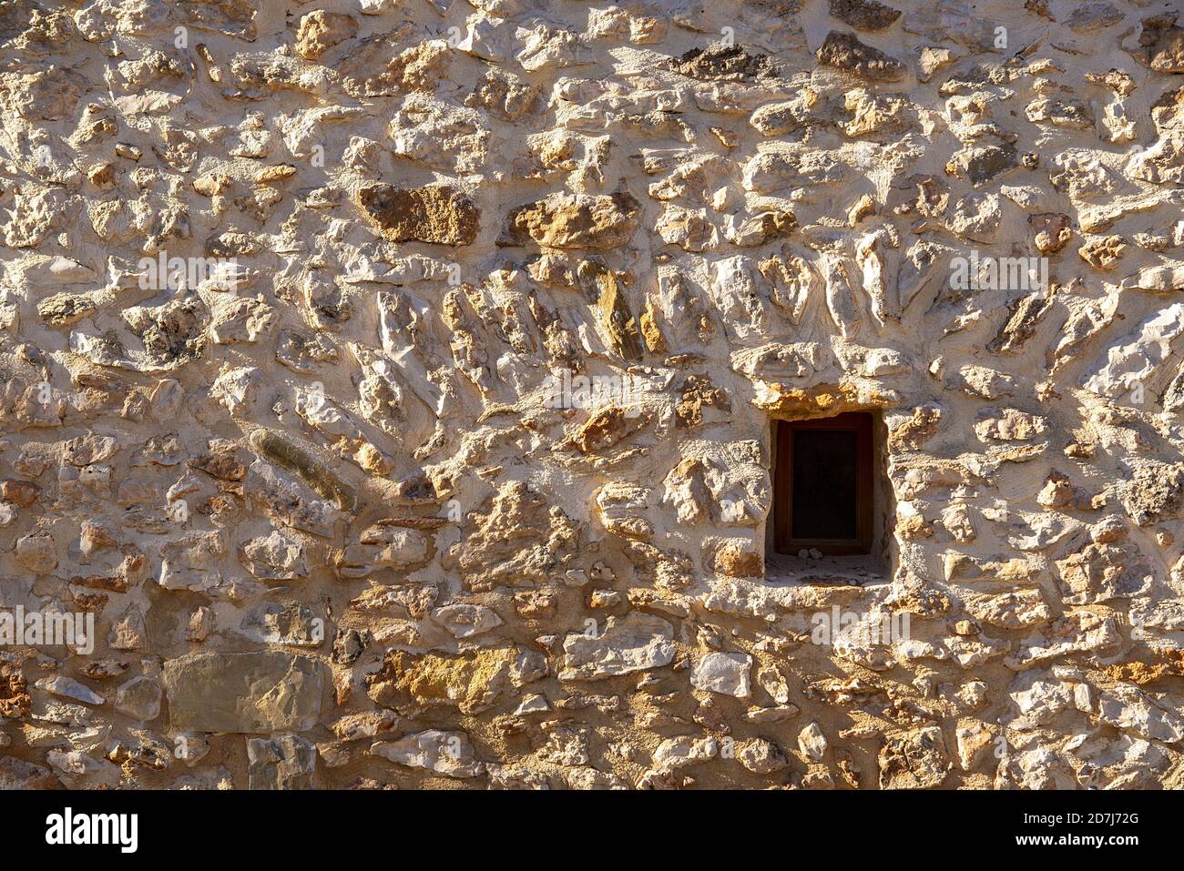 Natural stone wall with a small window Stock Photo - Alamy