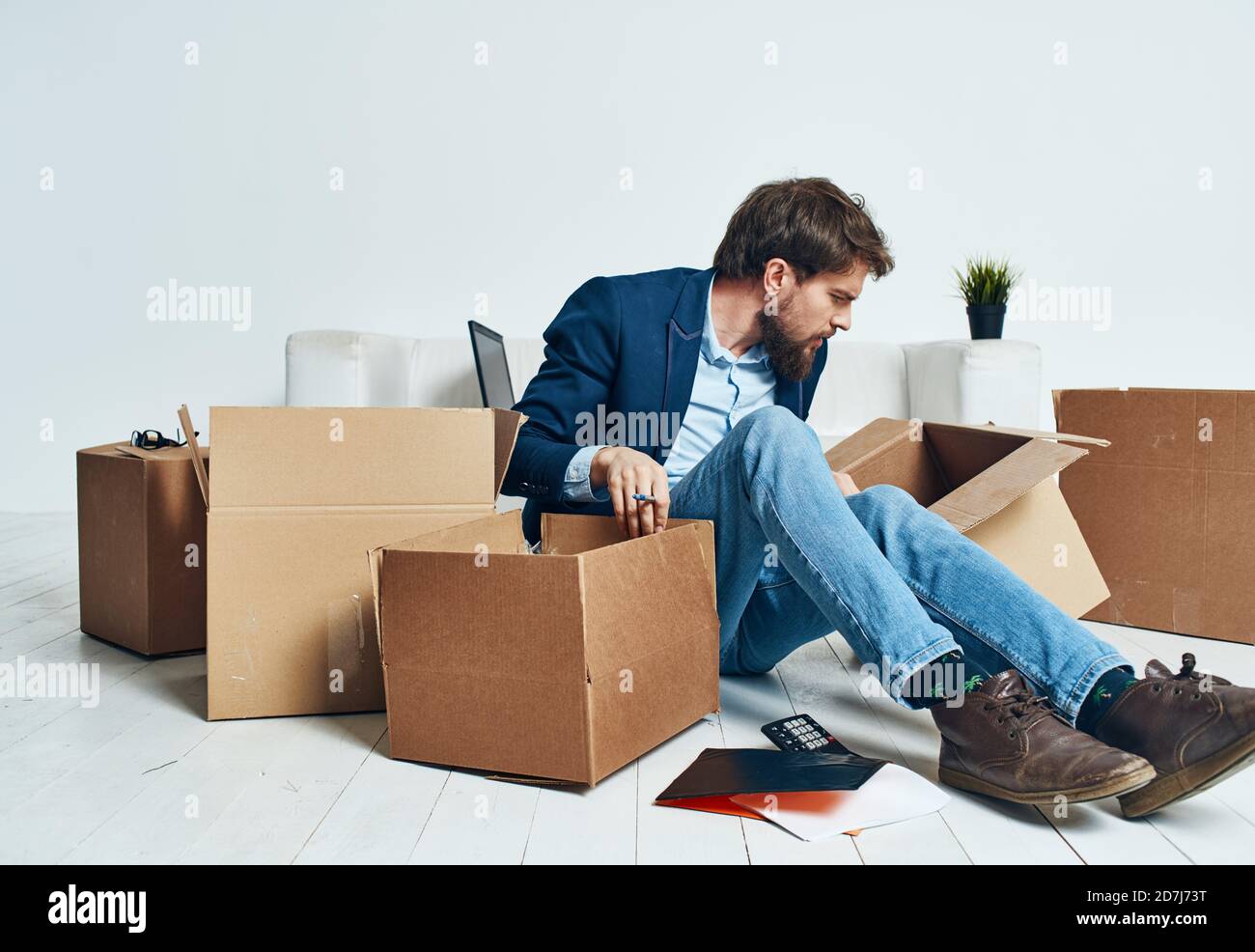 Business man picking up cardboard boxes and moving to a new place ...