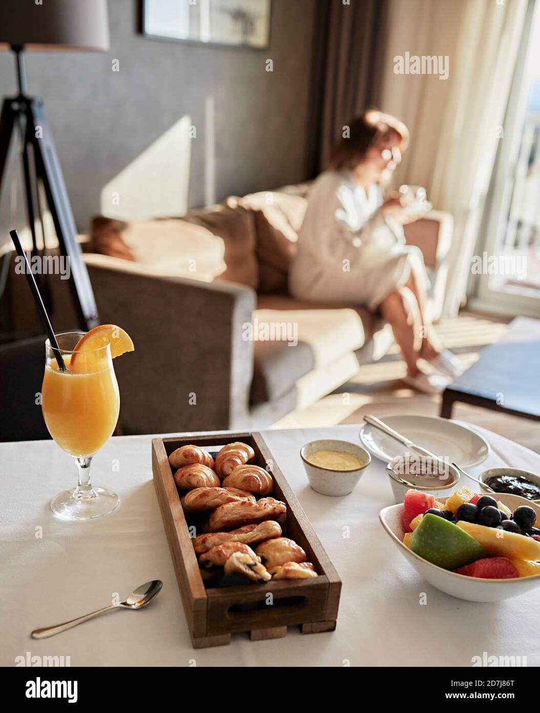 Fresh breakfast on table with senior woman sitting on sofa at luxury ...