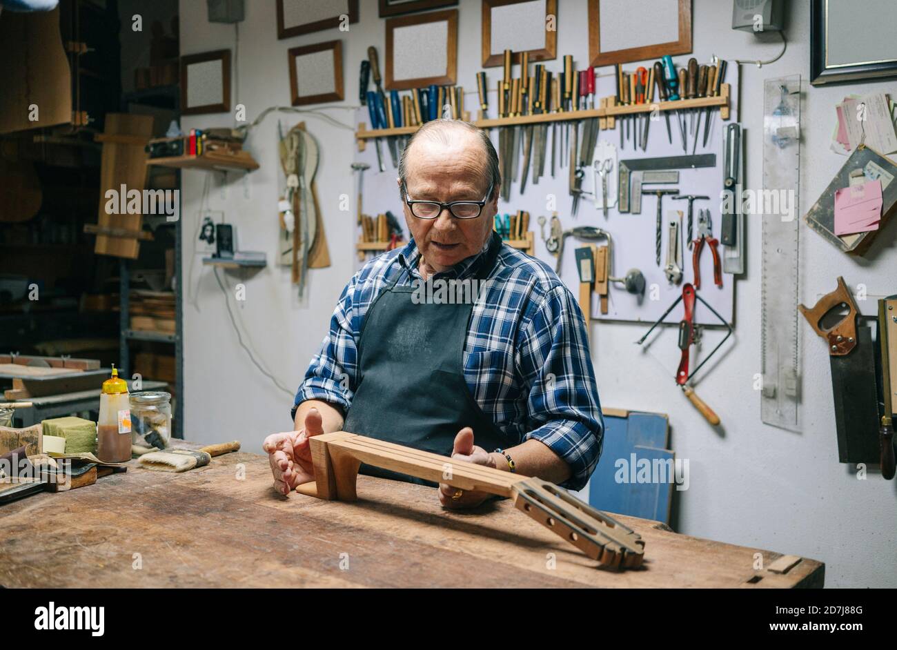 Luthier making fretboard of guitar while standing at workshop Stock ...
