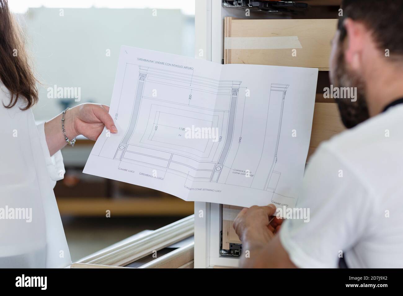 Interior designer showing design of drawer to carpenter while standing ...