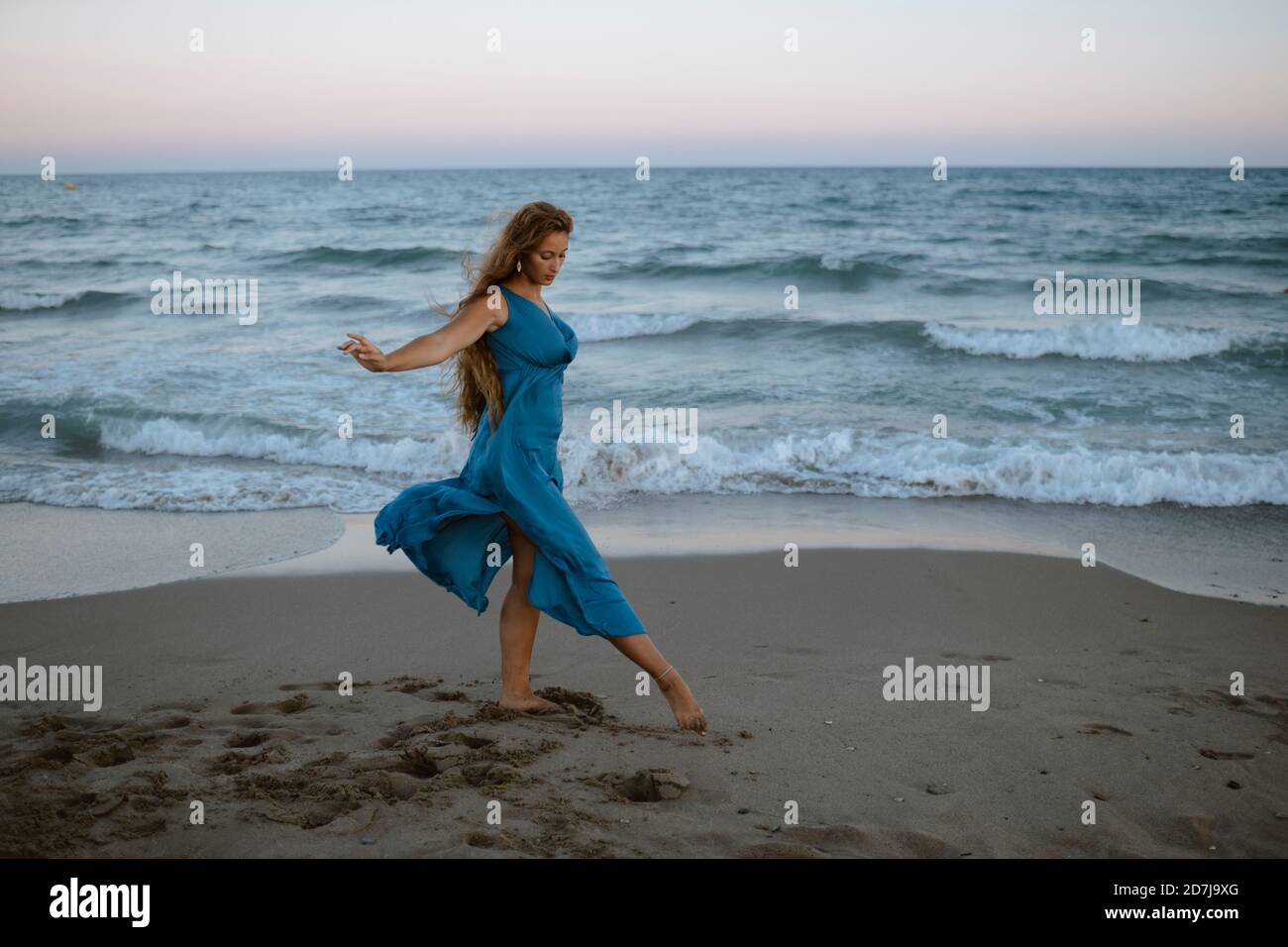 Beautiful woman dancing while standing at beach Stock Photo - Alamy