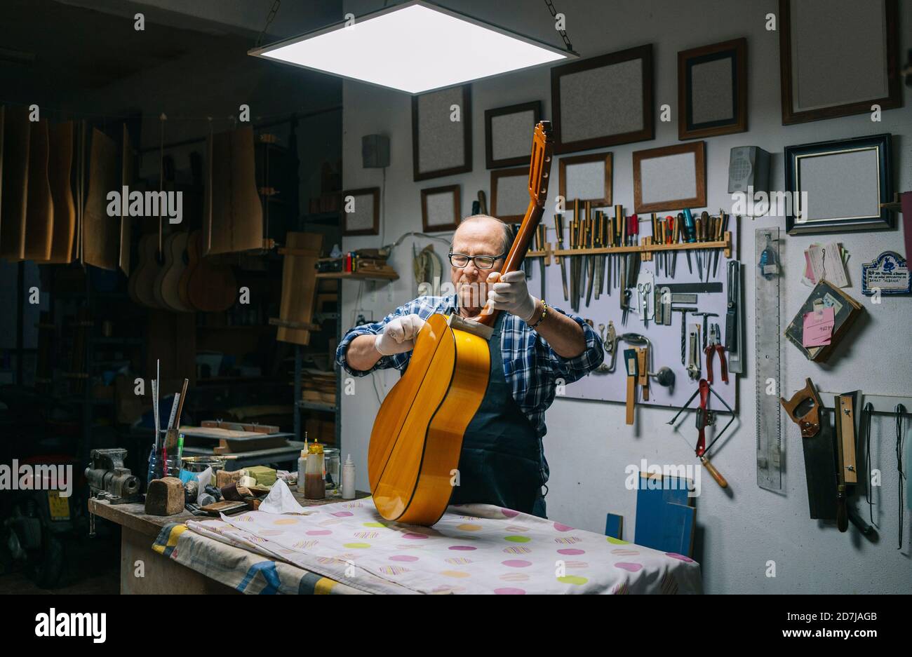 Man holding guitar on workbench while working at workshop Stock Photo ...