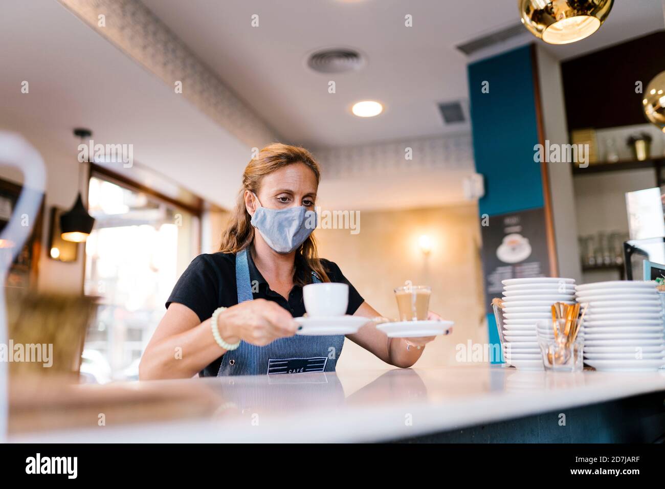 Female barista serving coffee at counter in cafe Stock Photo - Alamy