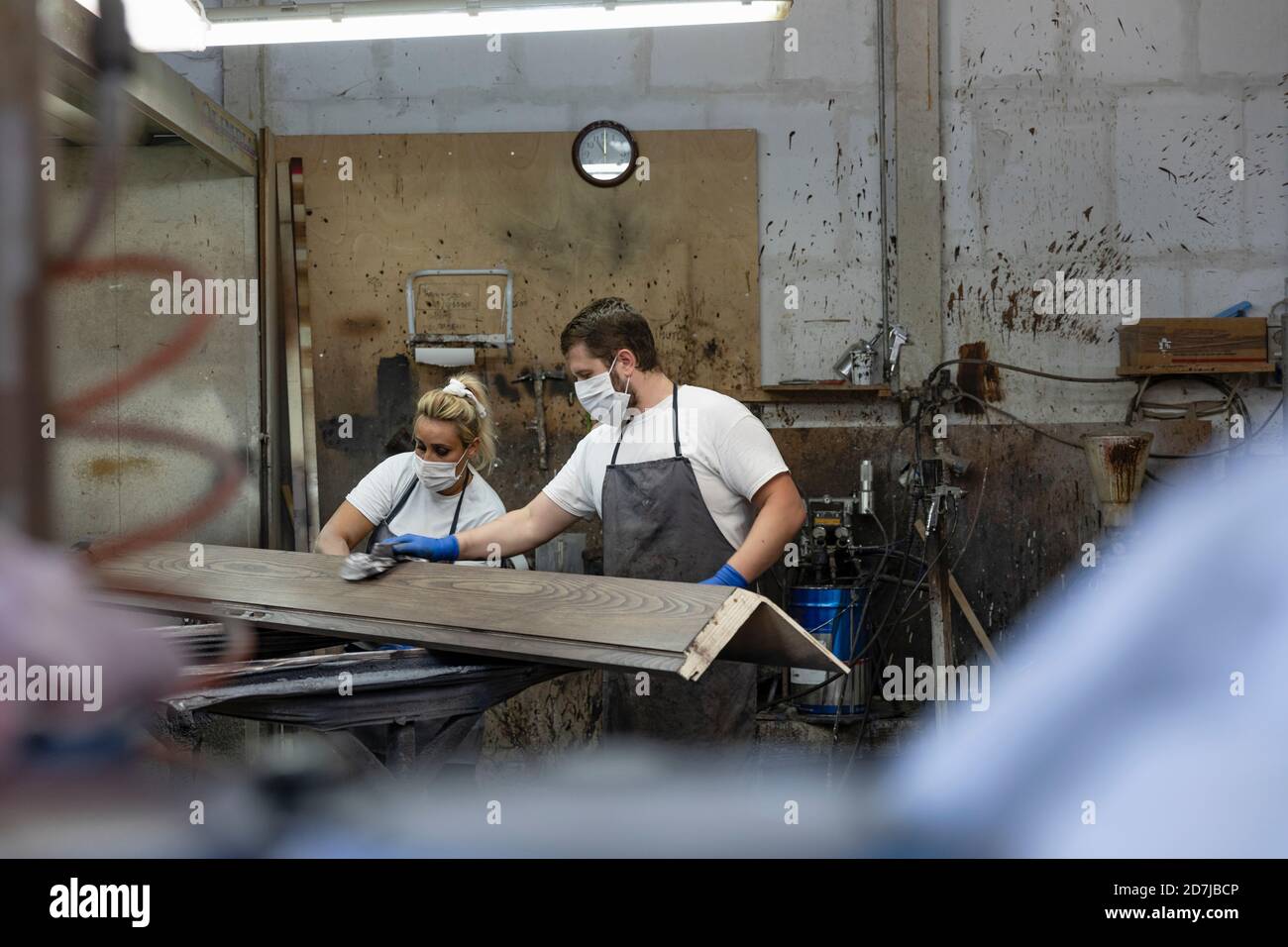 Carpenter team polishing wood while standing at factory Stock Photo - Alamy