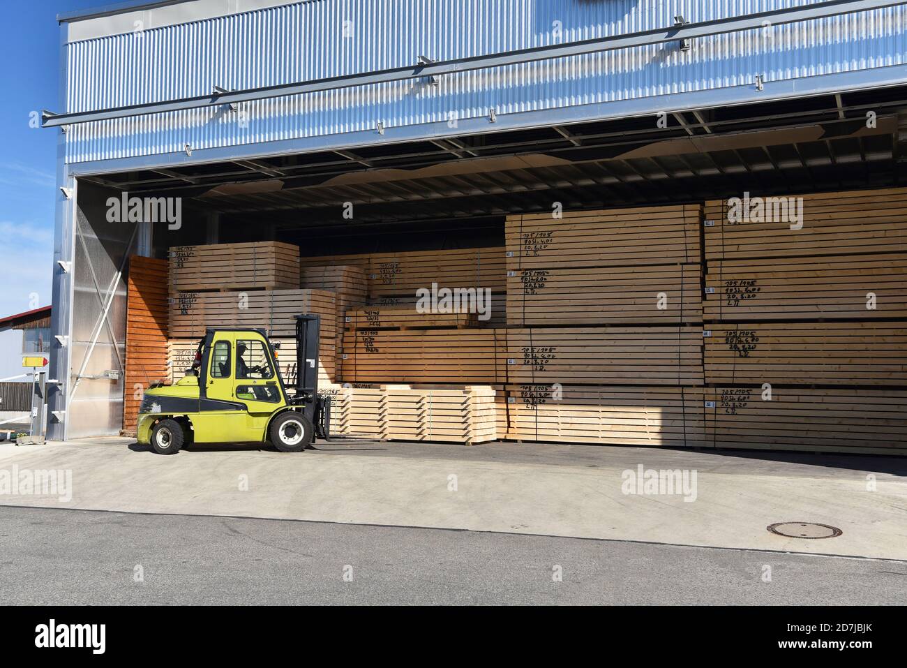 Forklift stacking planks inside lumberyard warehouse Stock Photo - Alamy