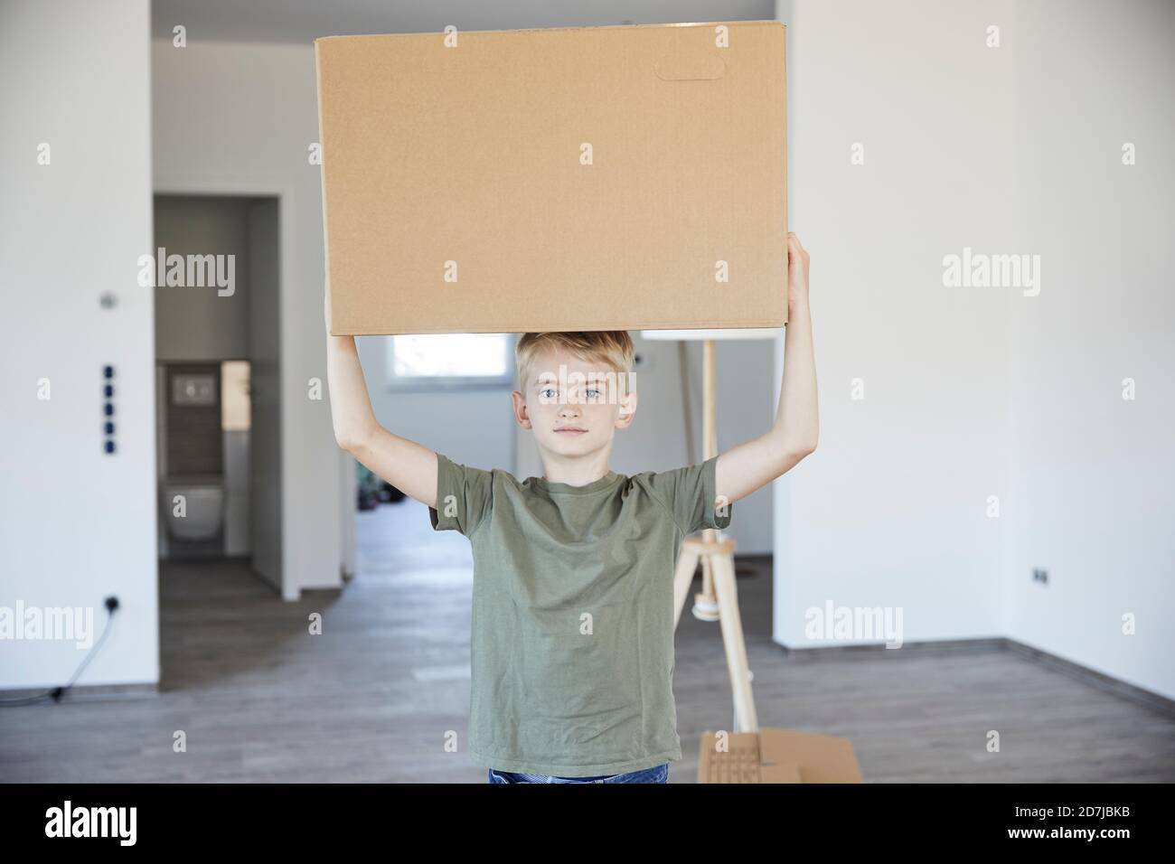 Little boy carrying cardboard box on head Stock Photo - Alamy