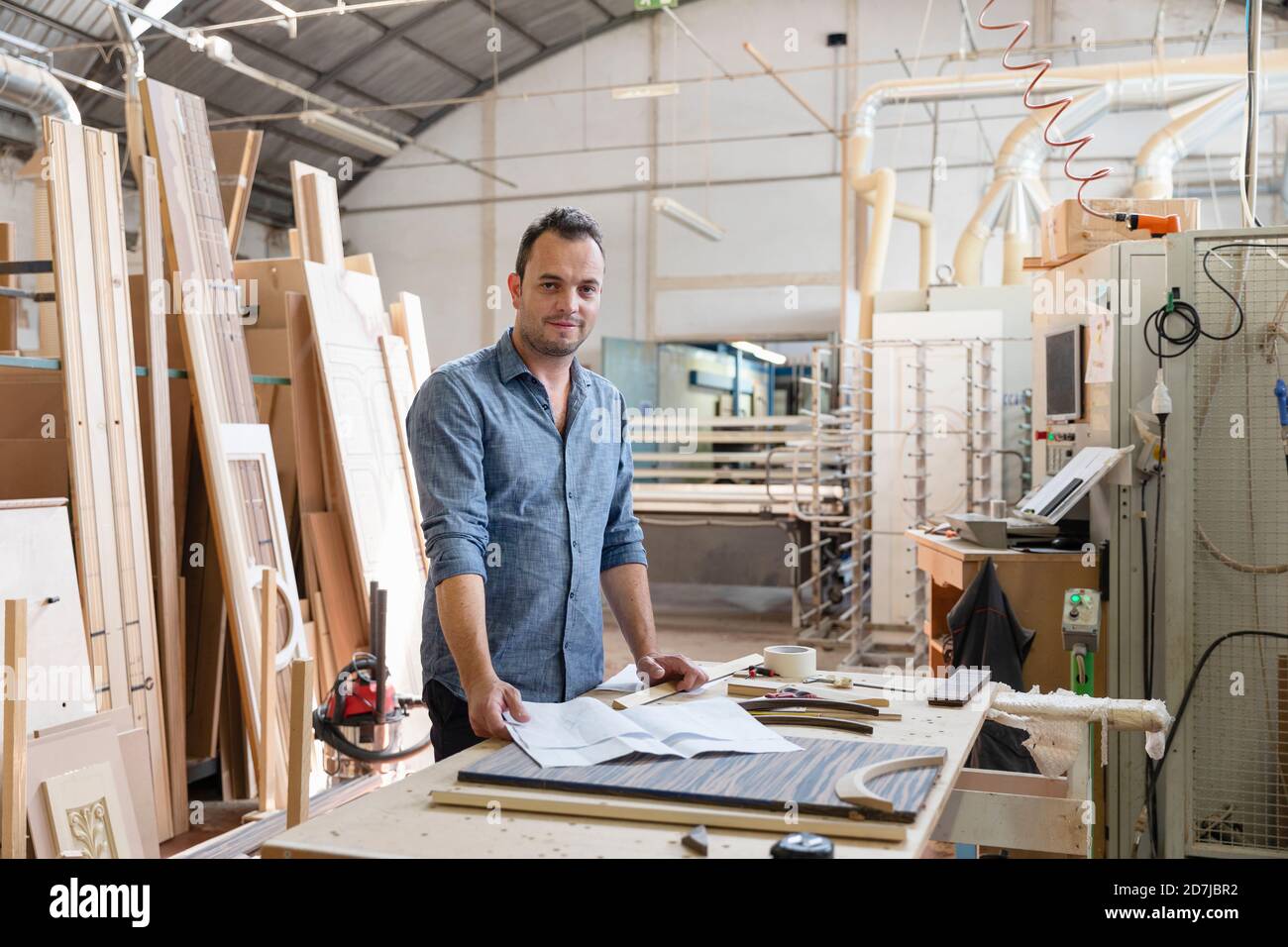 Project manager smiling while standing at factory Stock Photo - Alamy