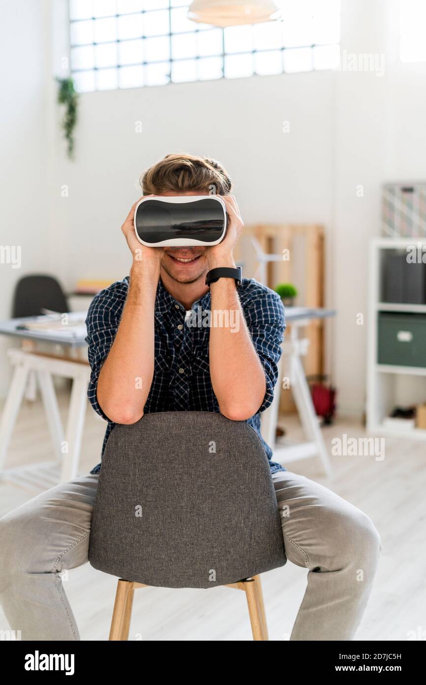 Architect smiling while using visual reality simulator sitting on chair ...