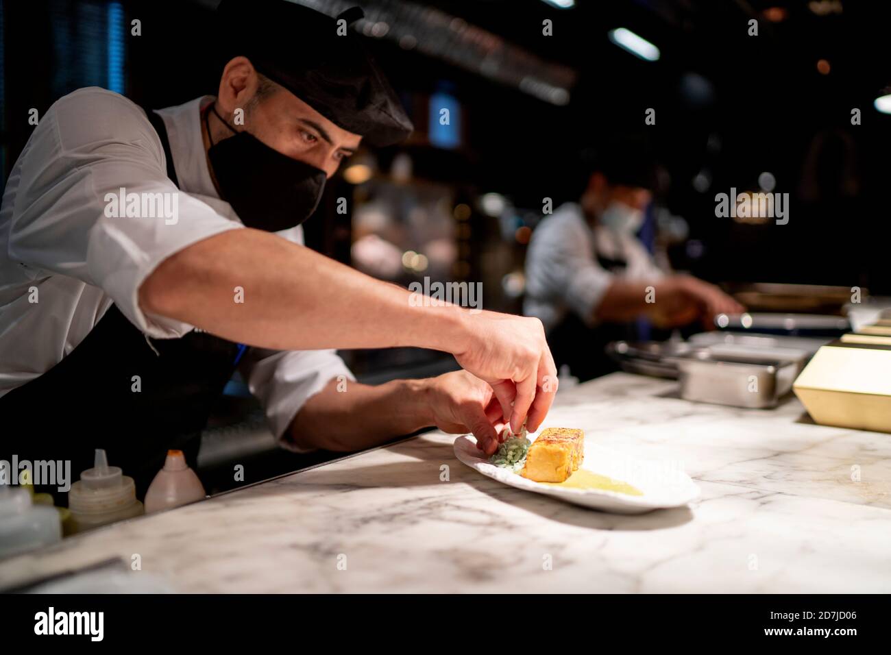 Chef garnishing pudding while standing in restaurant kitchen Stock ...