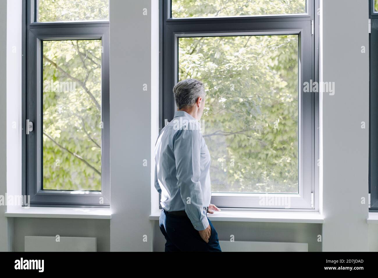 Man office window standing hi-res stock photography and images - Alamy