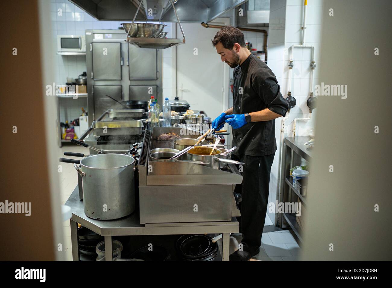 Man cooking while standing at commercial kitchen Stock Photo - Alamy