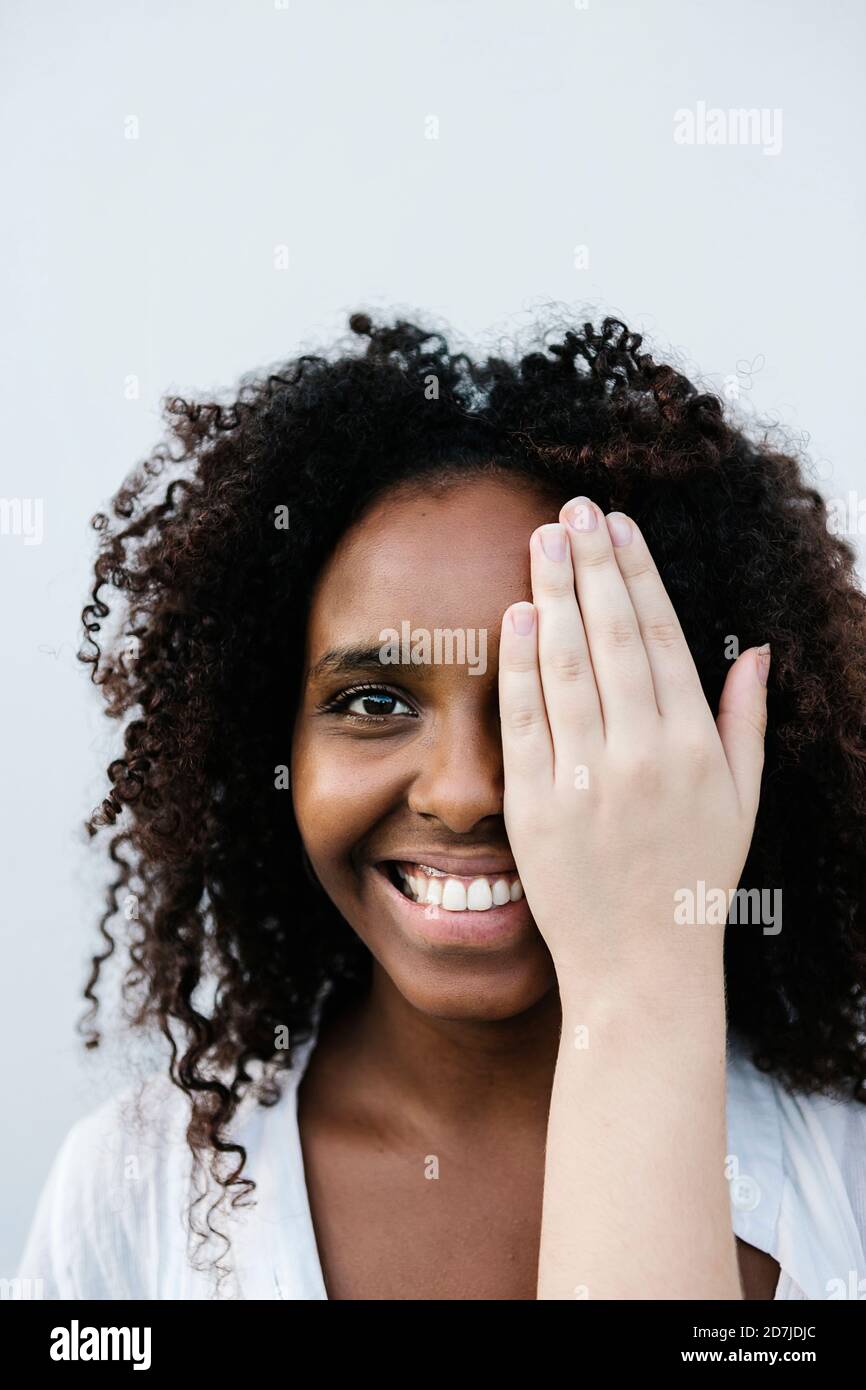 Hand covering face of smiling woman Stock Photo - Alamy