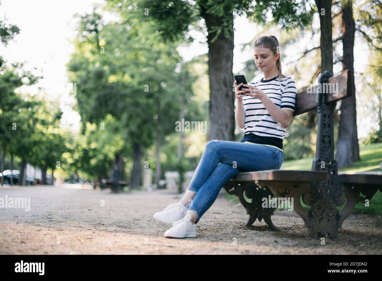 Texting in phone sitting park hi-res stock photography and images - Alamy