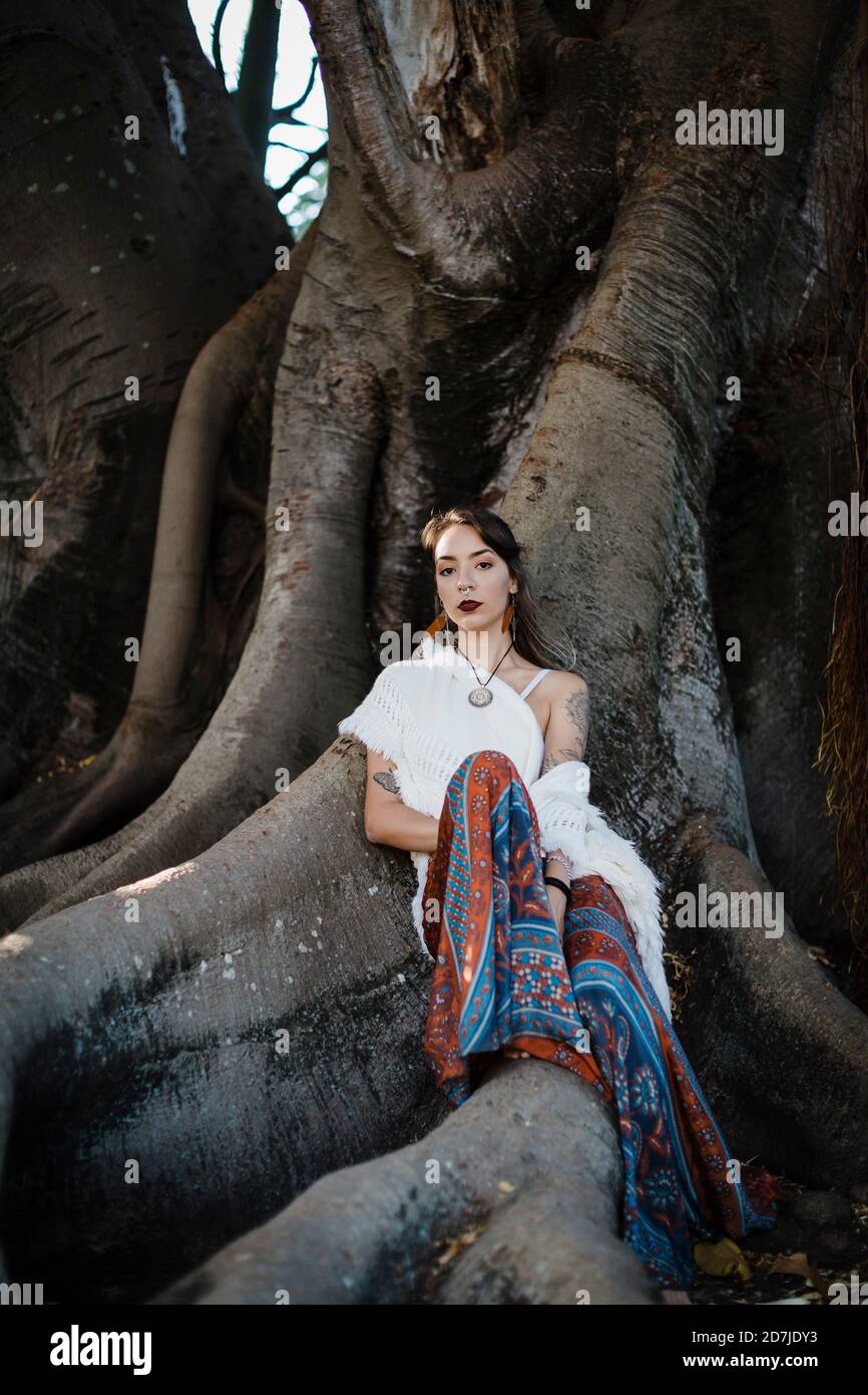 Woman resting while sitting under tree Stock Photo - Alamy