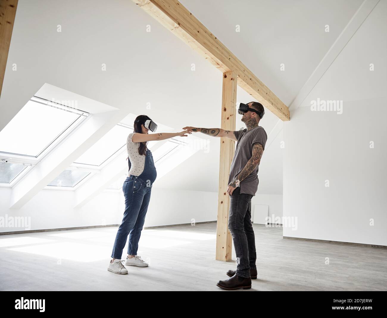 Couple pointing towards each other while wearing virtual reality ...