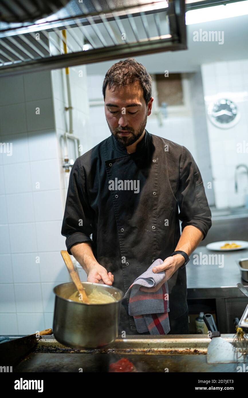 Chef looking down while working at kitchen Stock Photo - Alamy