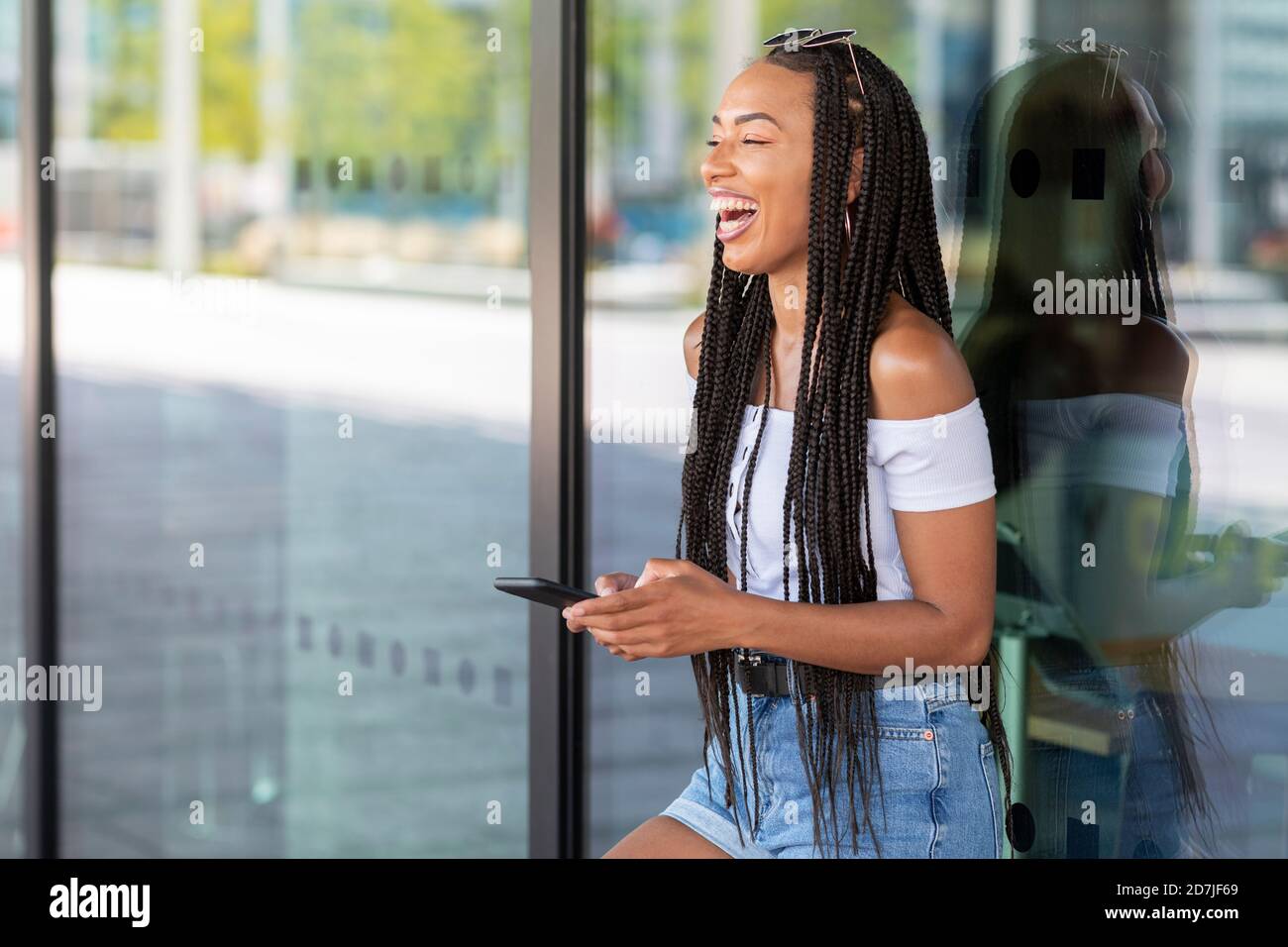 Woman leaning against wall using cell phone hi-res stock photography ...
