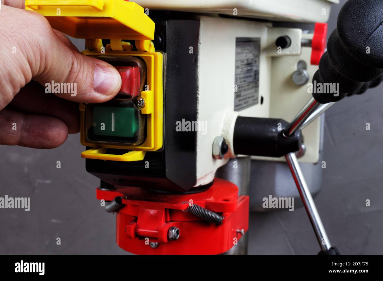 Worker presses the stop button on the drilling machine Stock Photo - Alamy