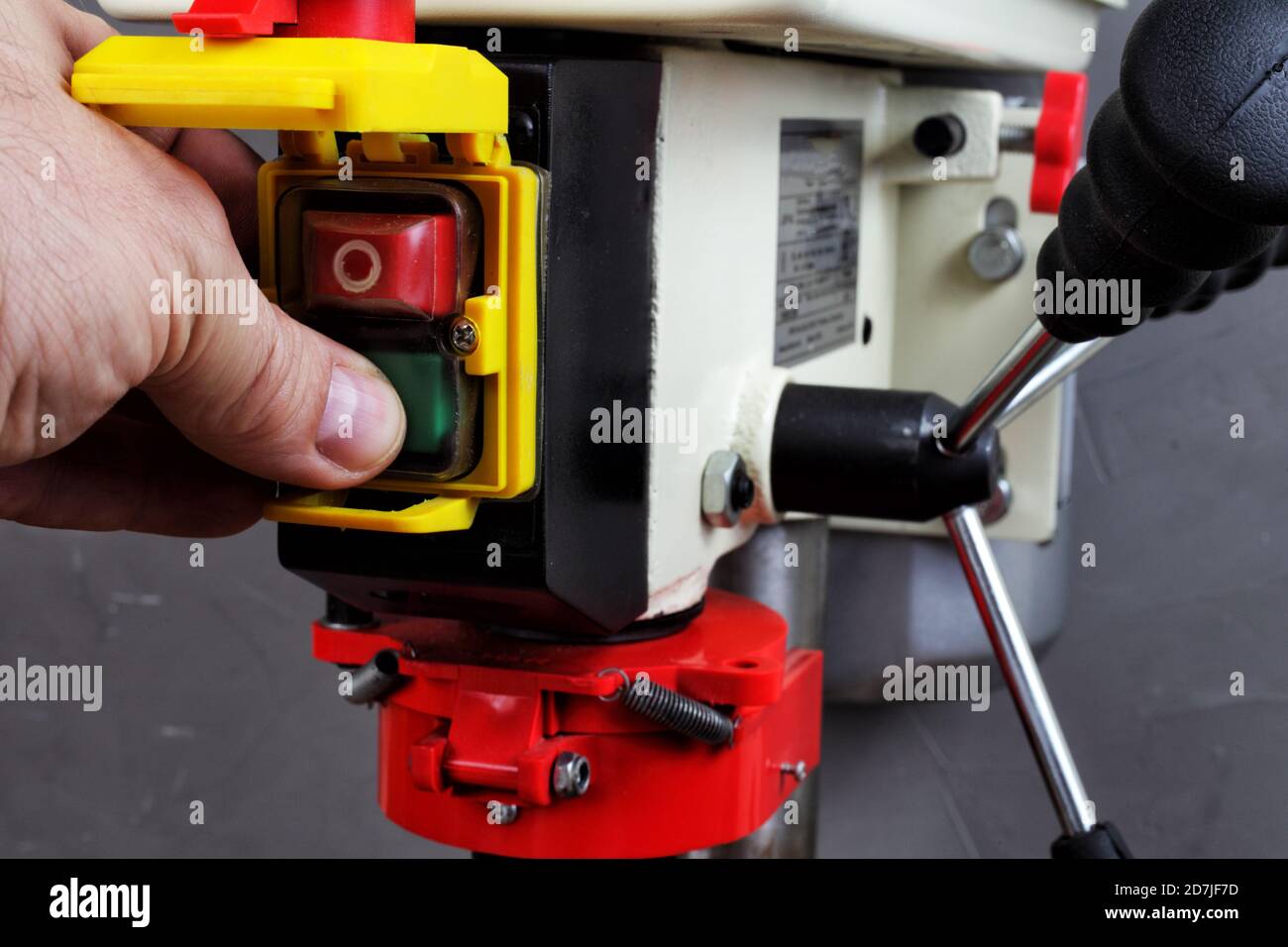 Worker presses the start button on the drilling machine Stock Photo - Alamy
