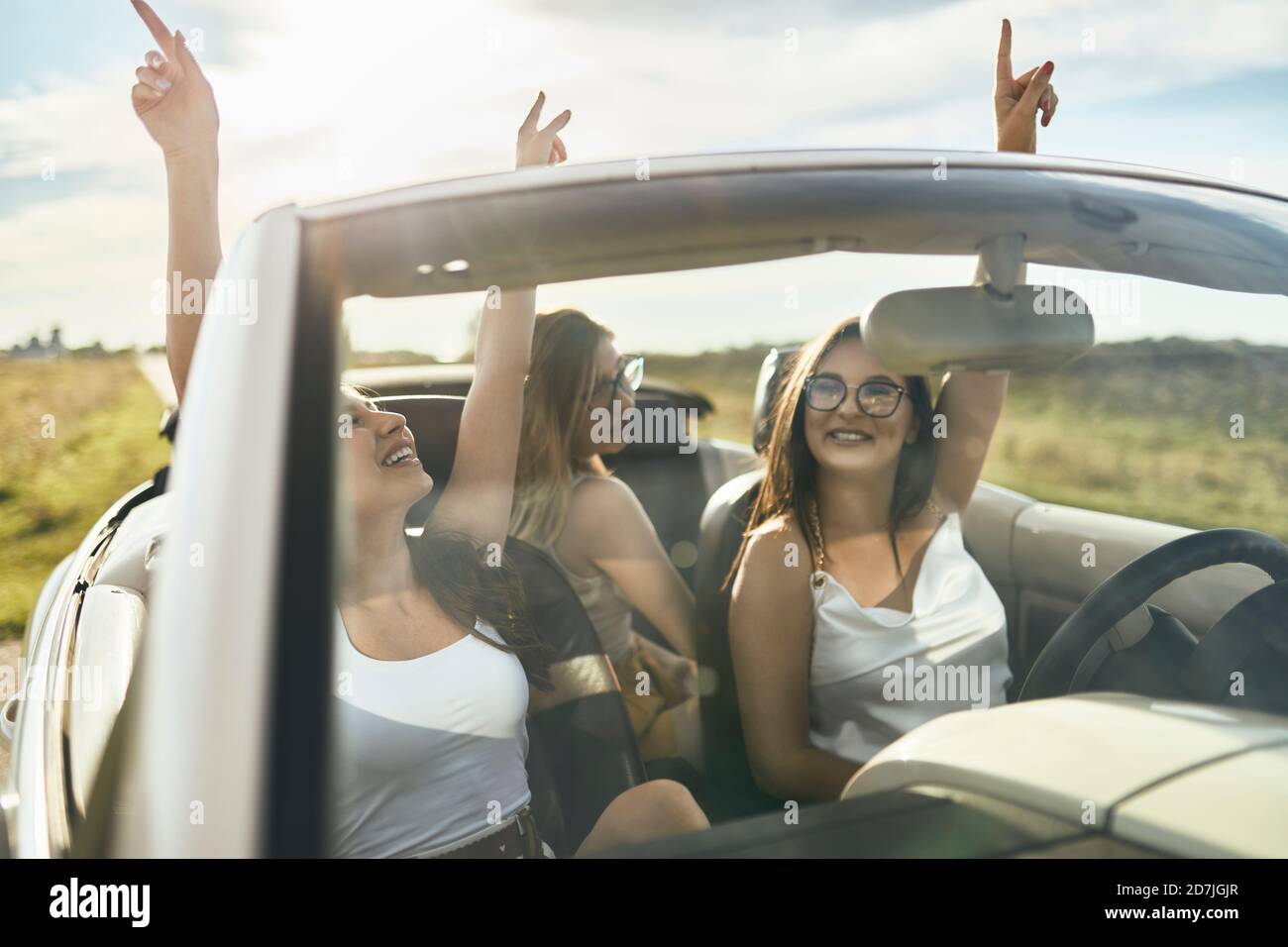 Young female friends having fun while dancing in convertible car Stock ...