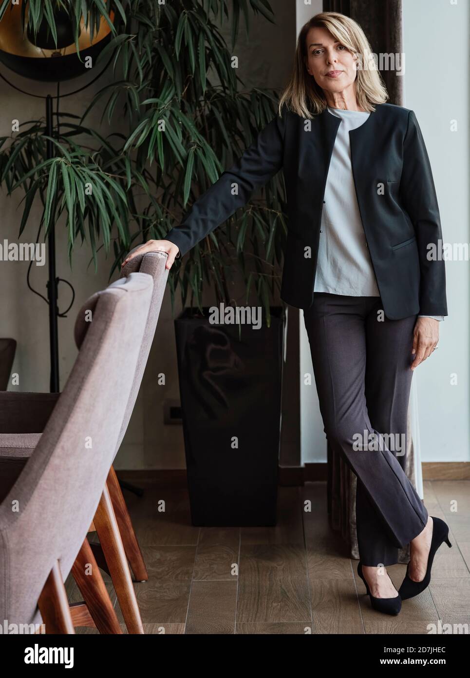 Senior woman standing in hotel lobby Stock Photo - Alamy