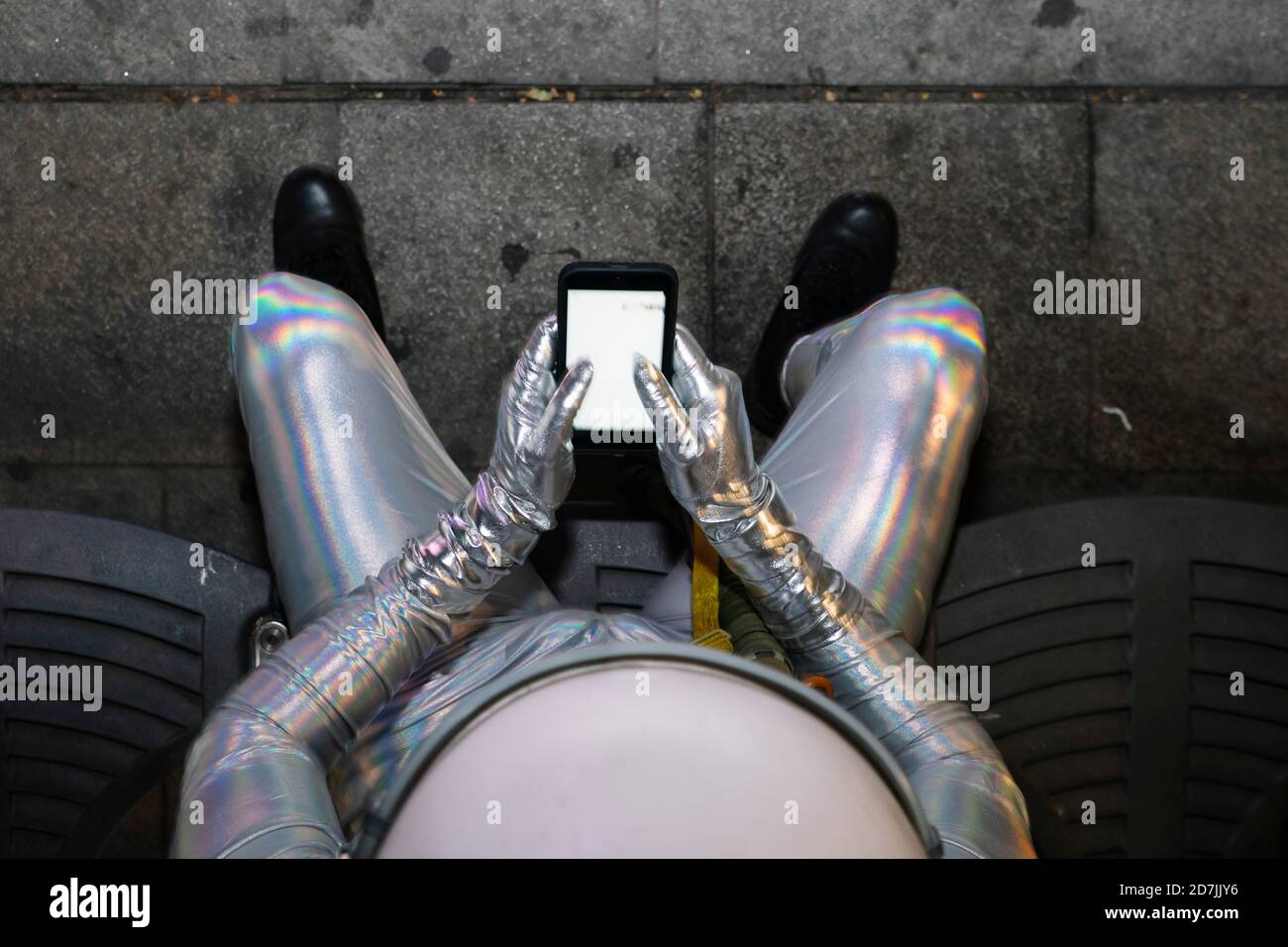 Male astronaut using mobile phone while sitting on seat at night Stock ...