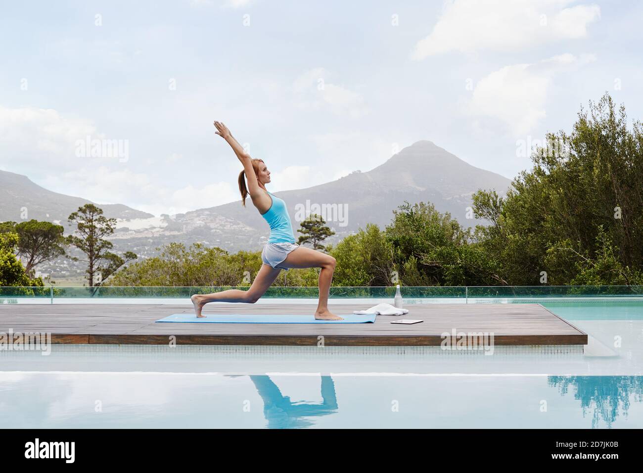 Young woman doing stretching exercise near swimming pool Stock Photo ...