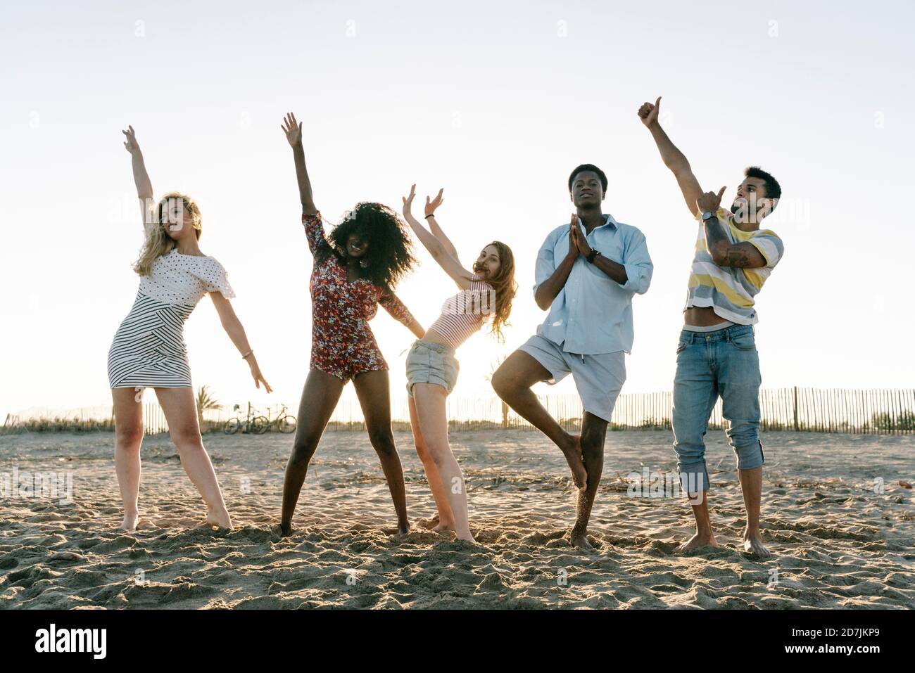 Friends enjoying while doing hand gestures standing on beach Stock ...