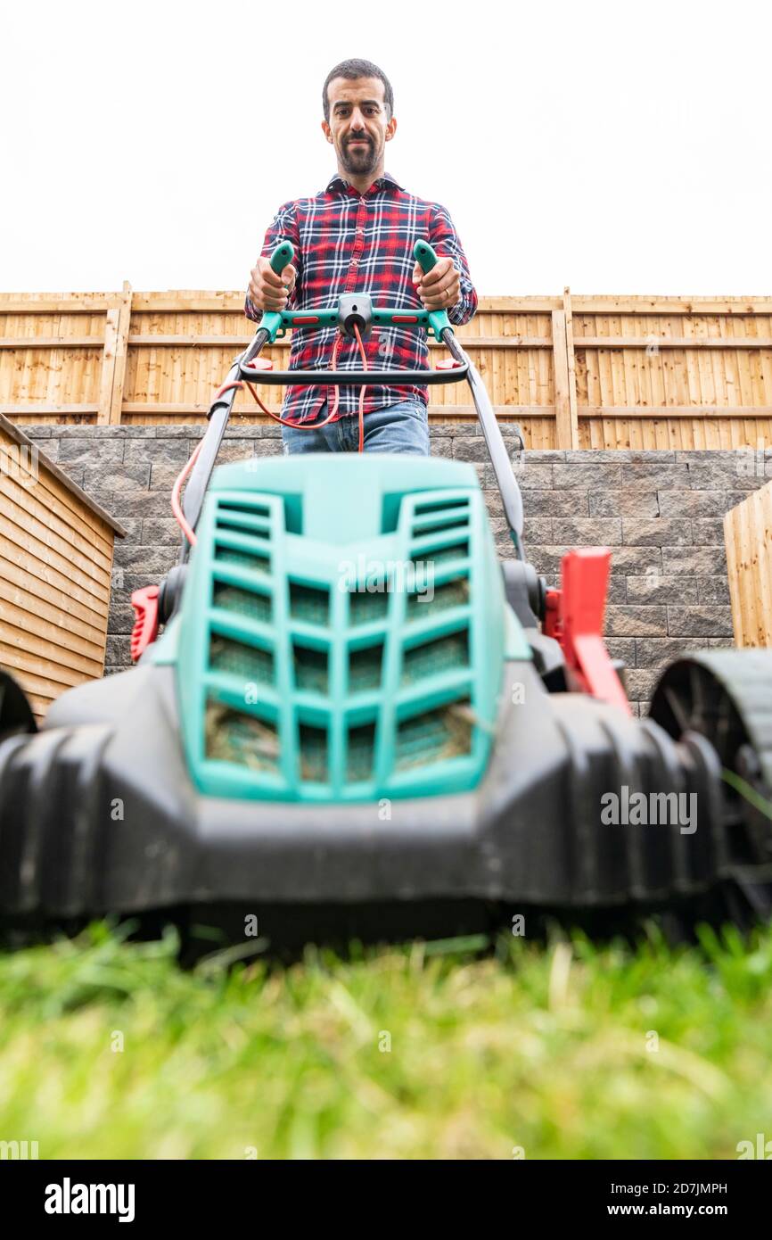 Man working with lawn mower at backyard Stock Photo - Alamy
