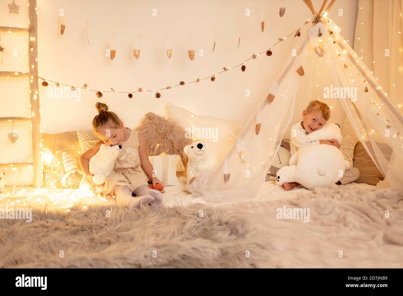 Brother and sister playing with teddy bear in room Stock Photo - Alamy